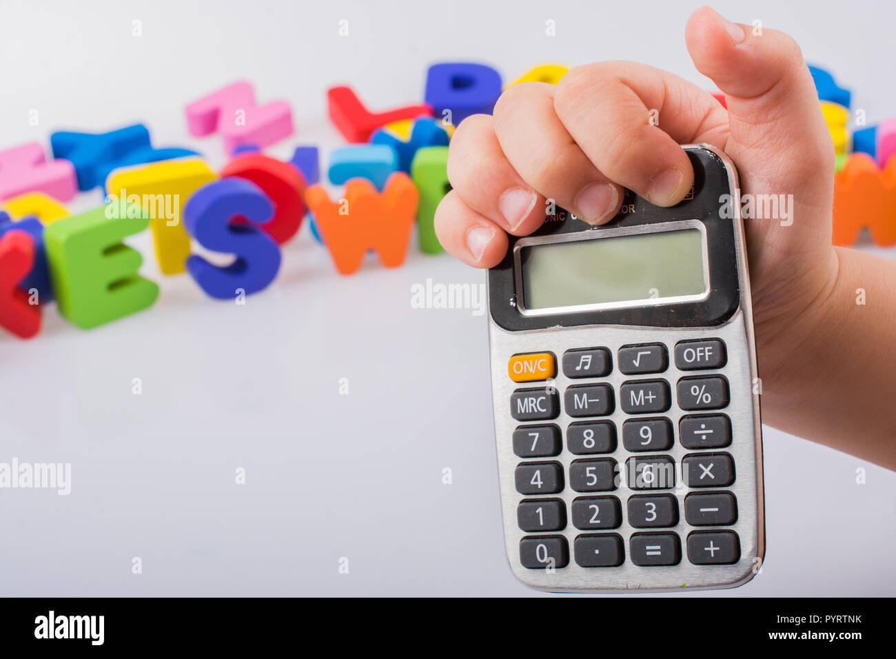 Little calculator in hand with colorful letters behind on white Stock ...
