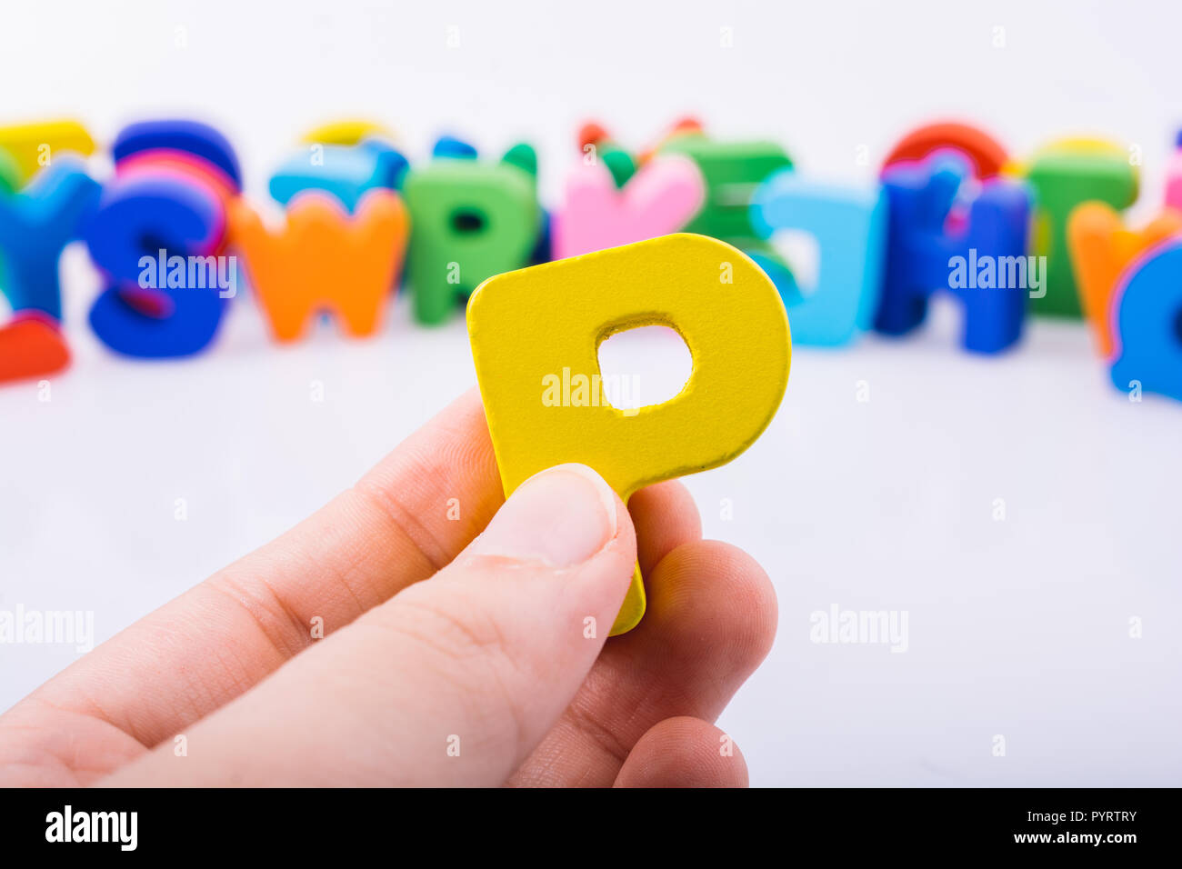 Hand holding letter cube P of made of wood Stock Photo - Alamy