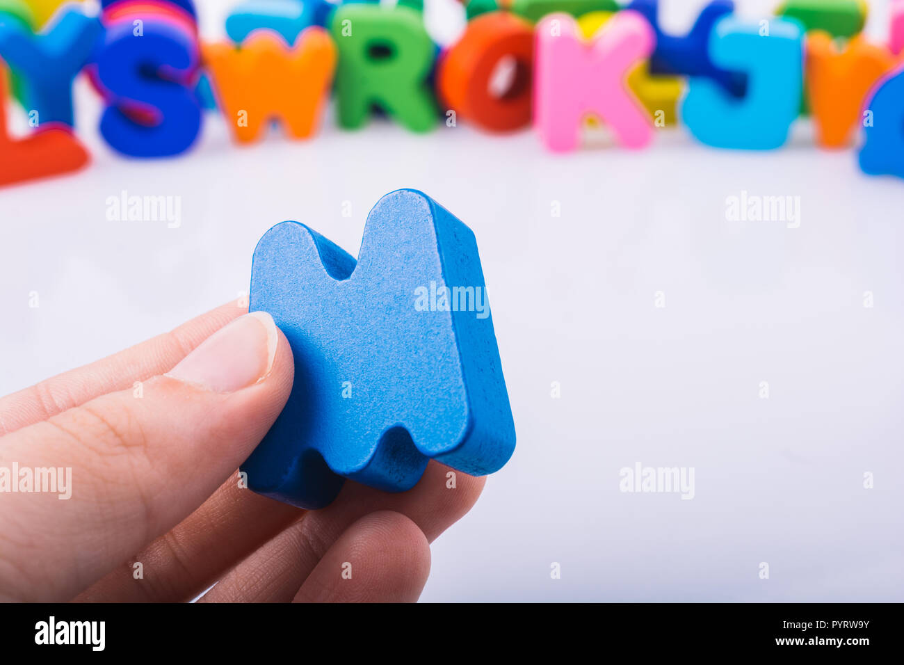 Hand holding letter cube M of made of wood Stock Photo - Alamy