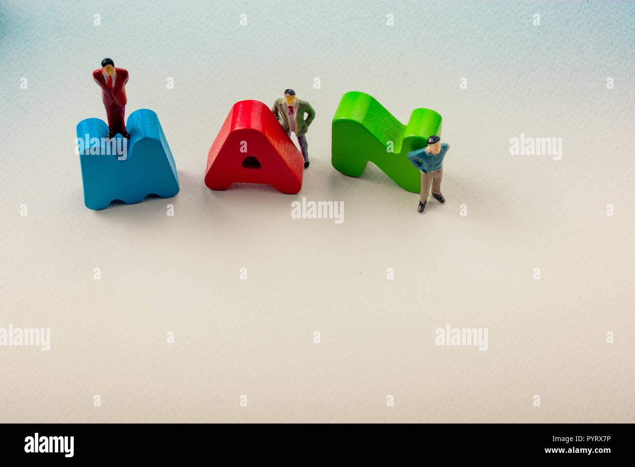 Tiny figurine of men beside colorful wooden letters say MAN Stock Photo ...