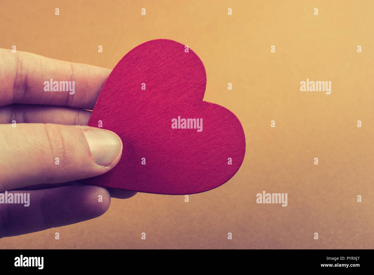 Red color heart shaped object in hand on dotted paper Stock Photo - Alamy