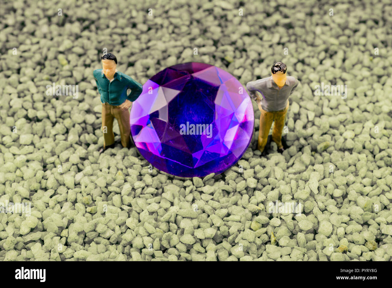 Tiny figurine of man miniature model and fake diomond gem Stock Photo ...