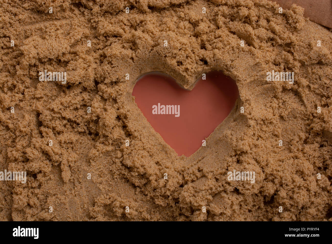 Heart shape made on the sand background in view Stock Photo - Alamy