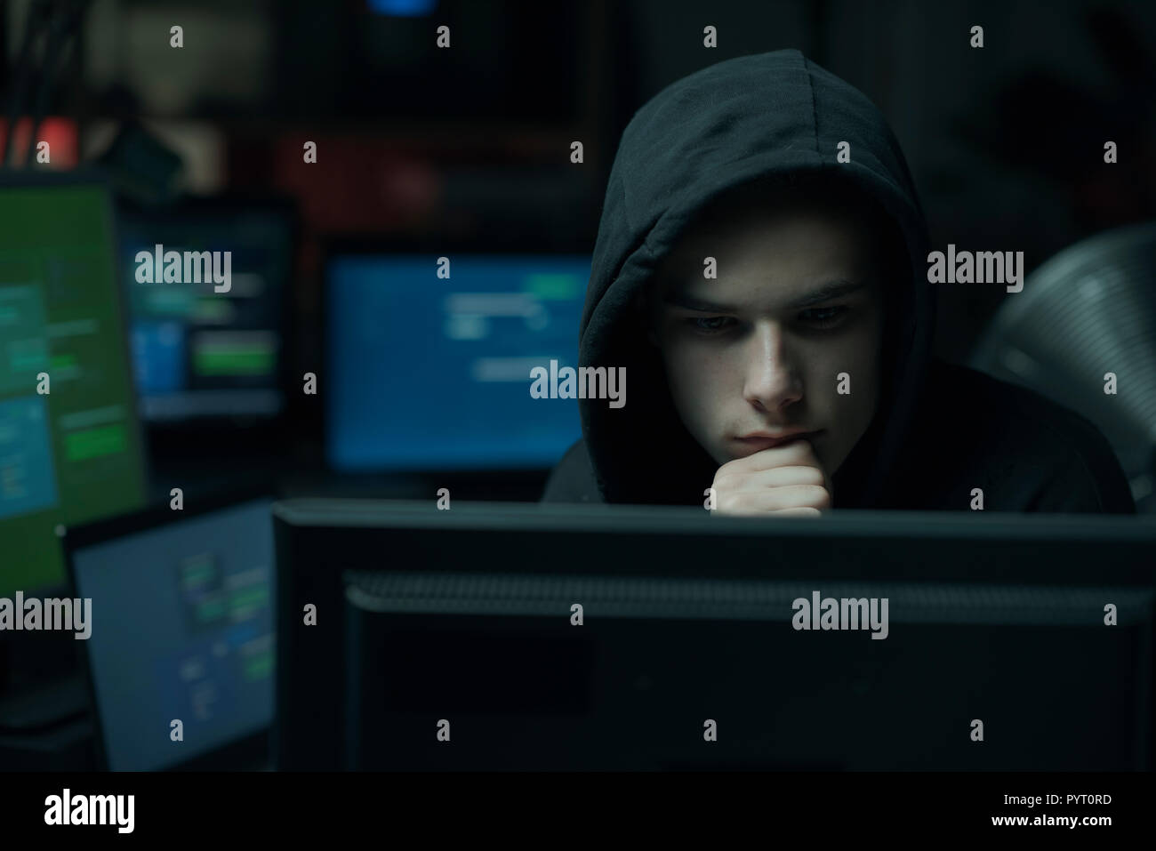 Cool young hacker with hoodie working with computers, cybercrime and ...