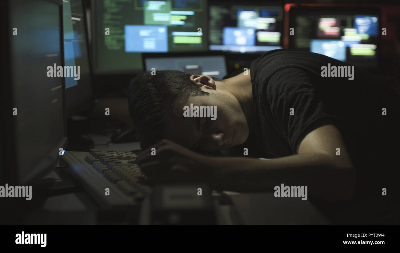 Hacker and computer developer sleeping on the desk late at night ...