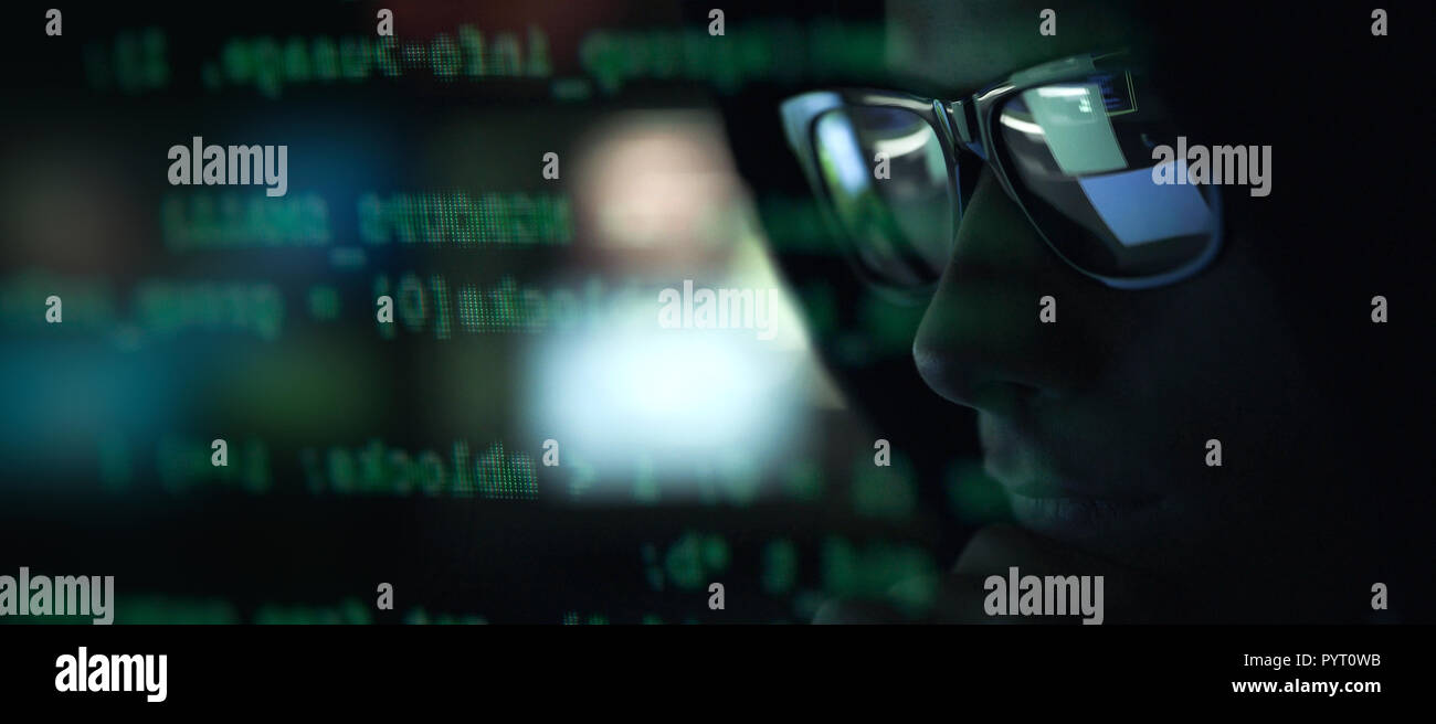 Cool hacker with sunglasses and programming code on the computer screen ...