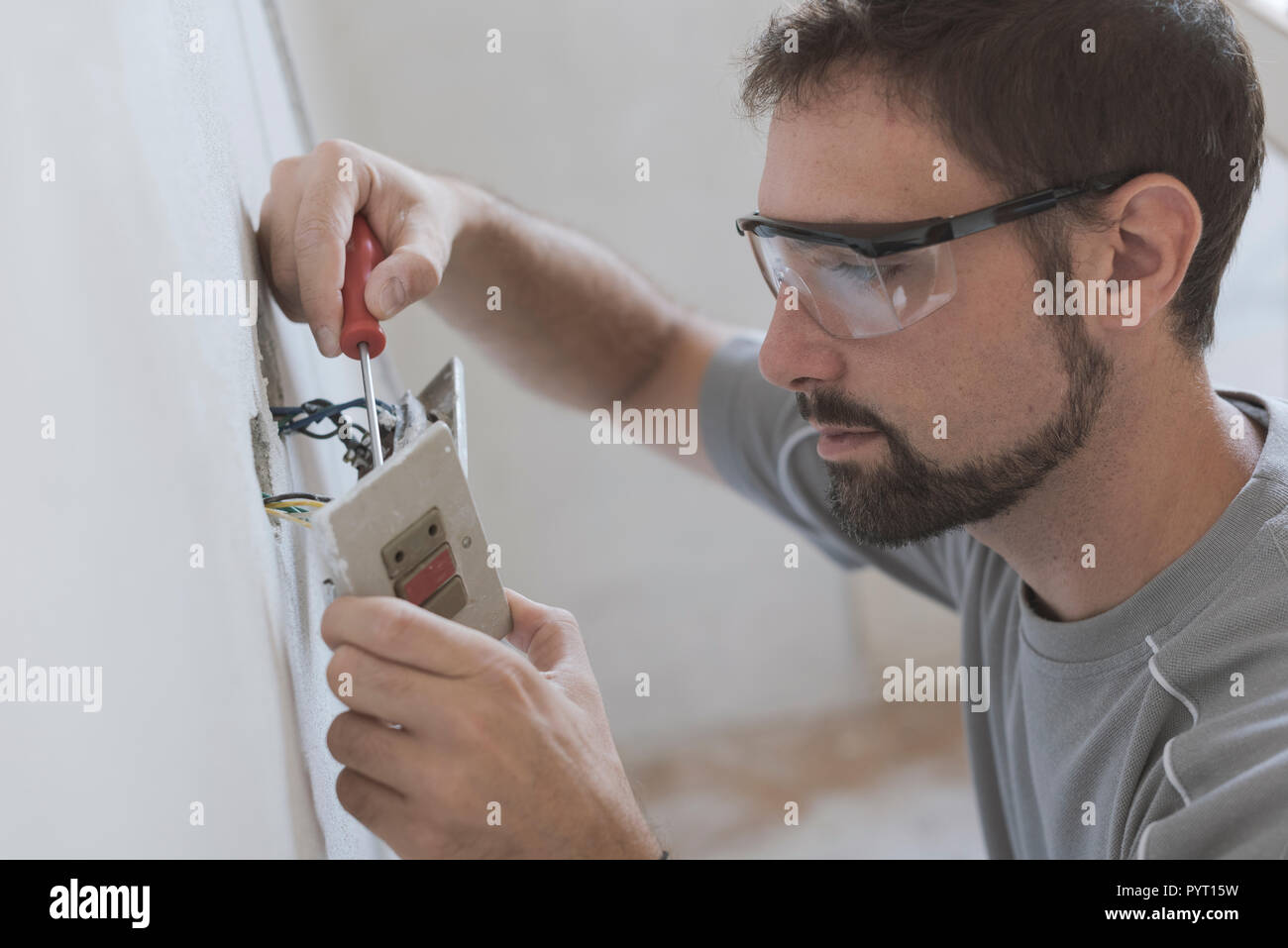 Professional electrician installing sockets using a screwdriver: home ...