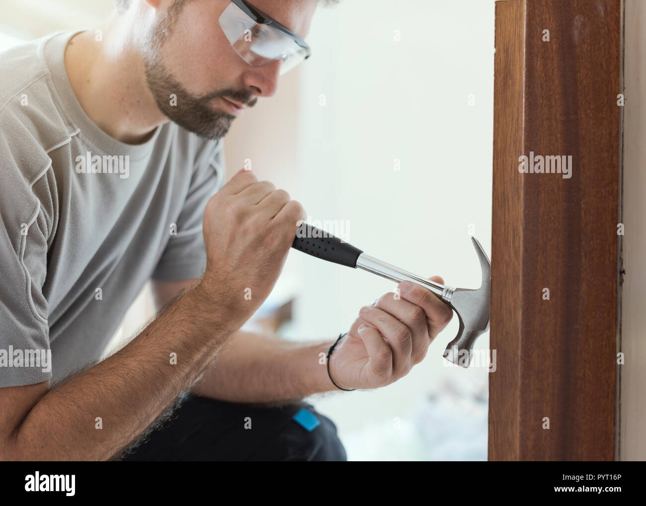 Professional carpenter removing an old door at home: home makeover and ...