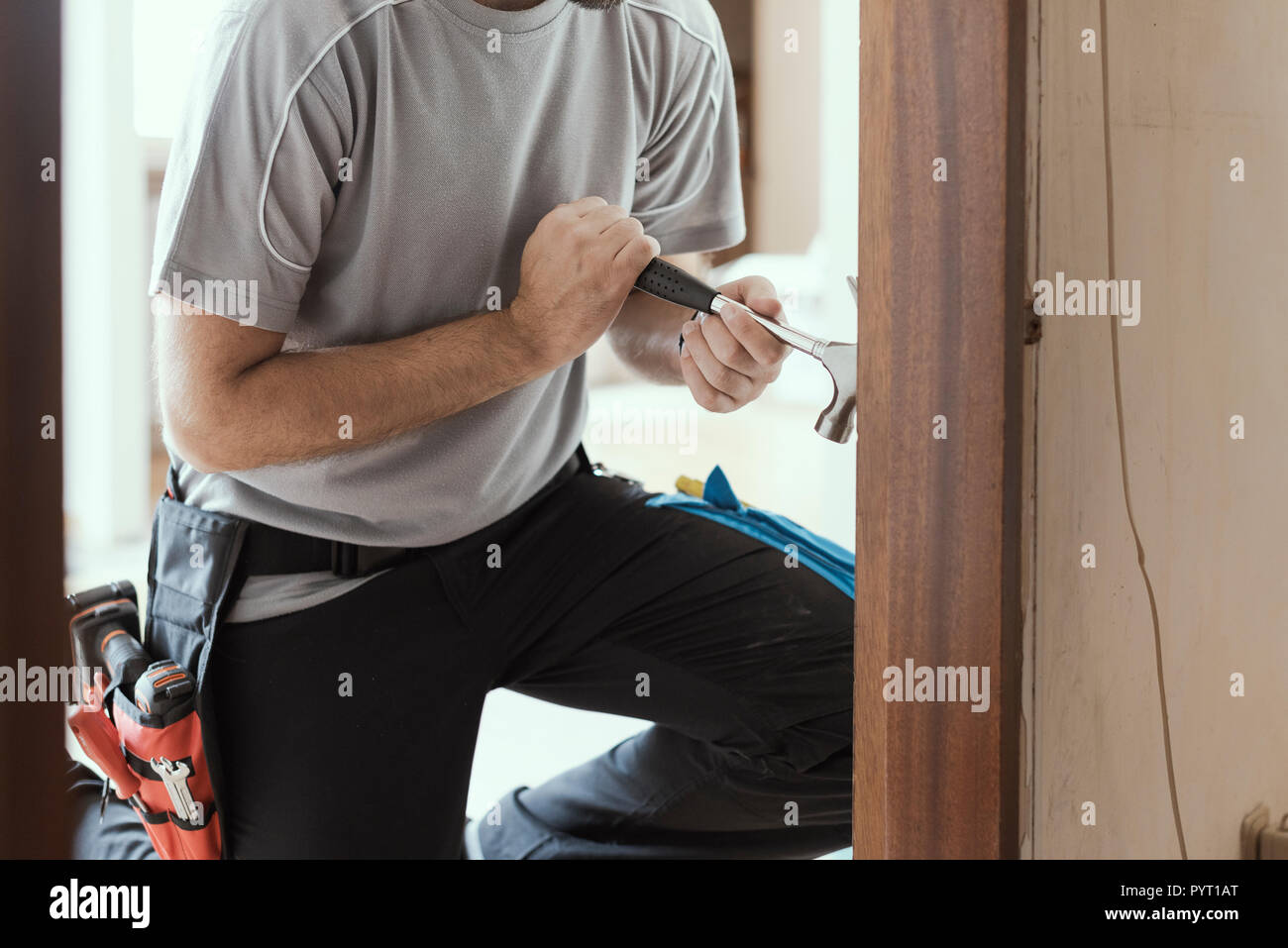 Professional carpenter removing an old door at home: home makeover and ...