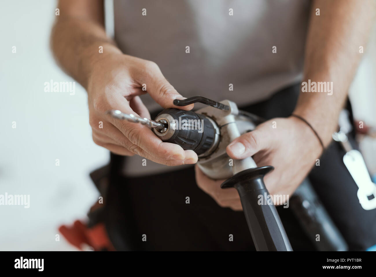 Professional handyman changing a drill bit: home renovation and manual ...