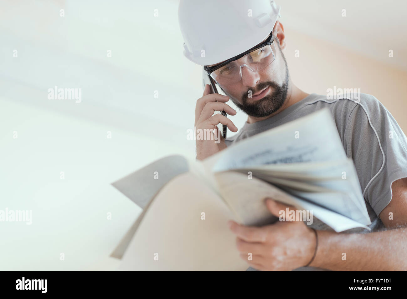 Professional construction worker checking a house project and calling ...