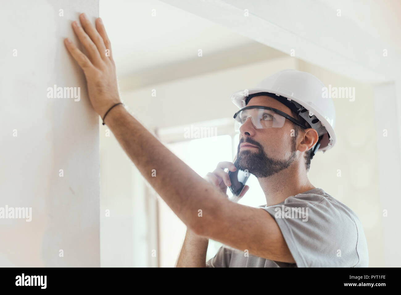 Professional builder with safety helmet having a phone call, home ...