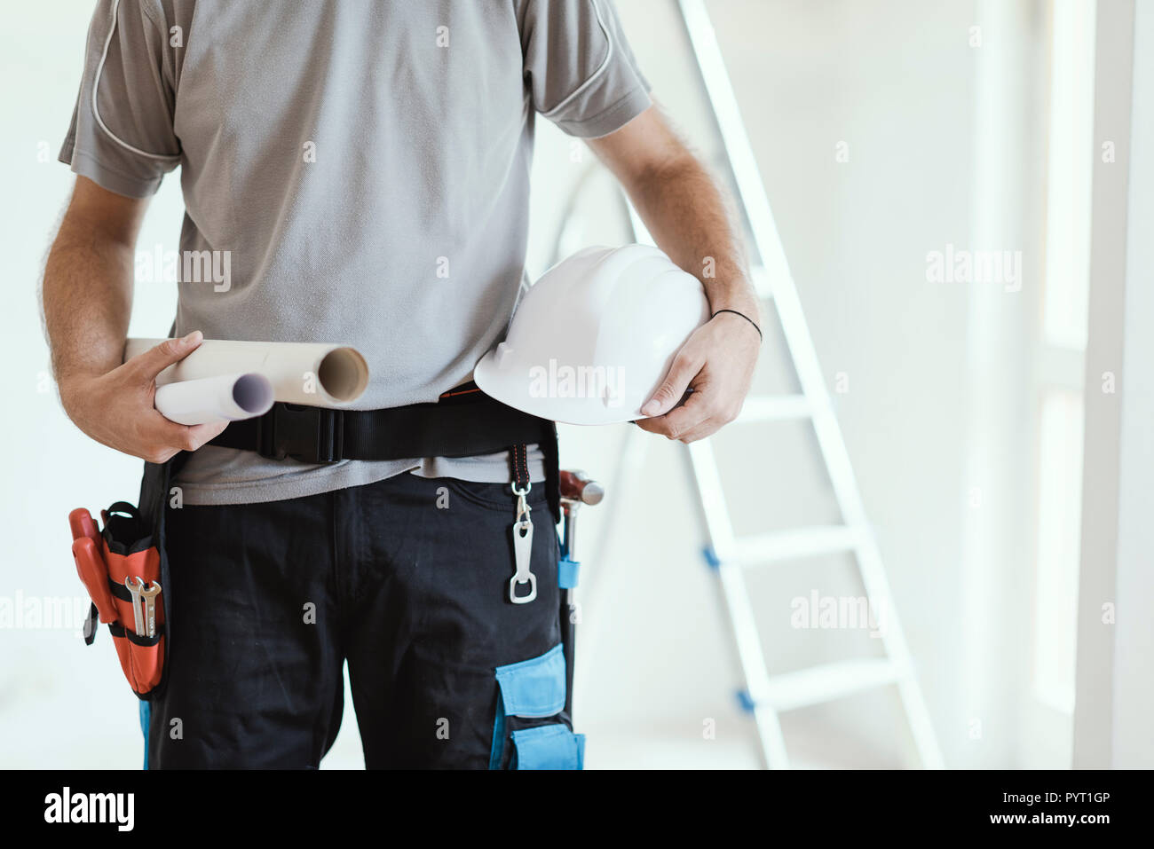 Professional construction engineer holding paper rolls and a safety ...