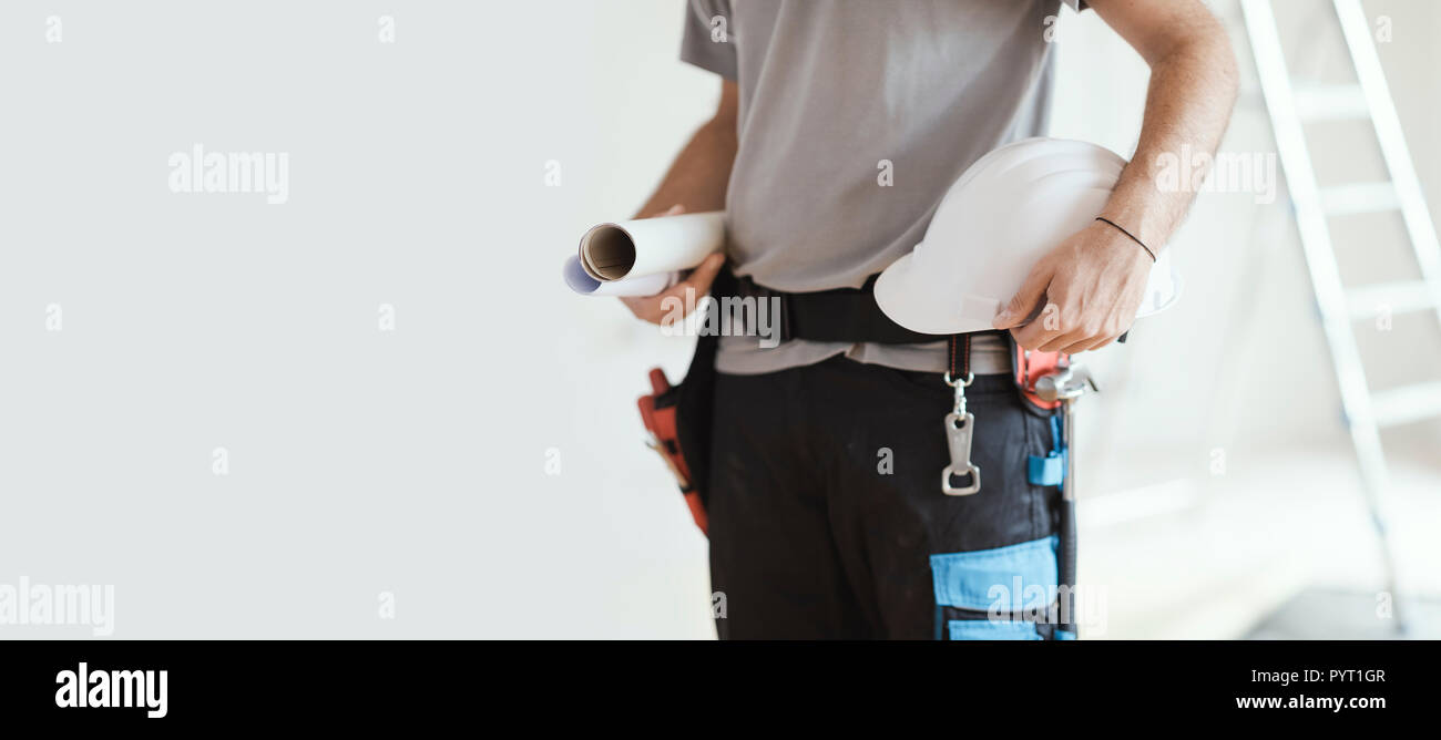 Professional construction engineer holding paper rolls and a safety ...