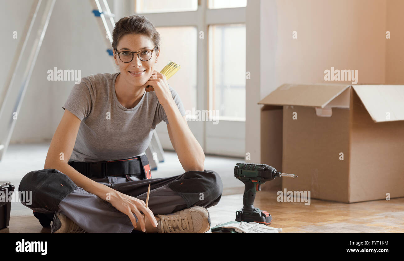 Young woman moving in her new house and doing a home makeover, she is ...