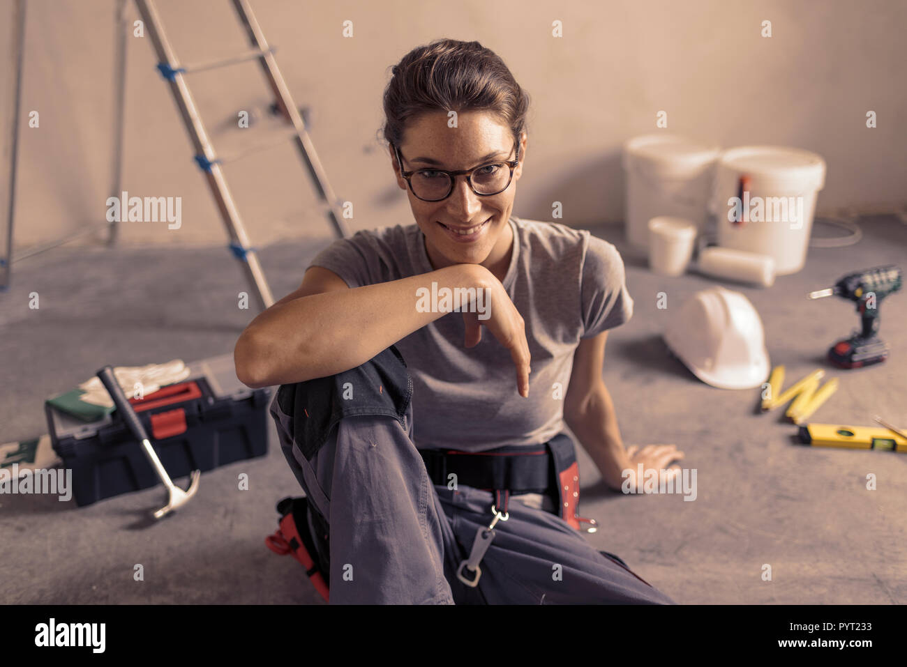 Attractive smiling woman renovating her house, she is sitting on the ...