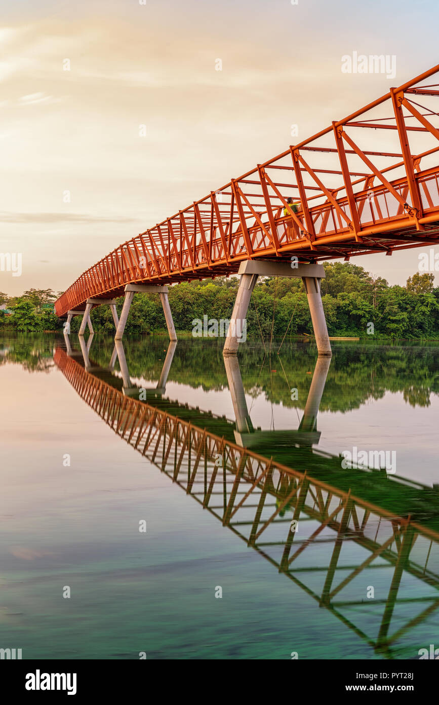 Long red steel bridge structure across river with reflection Stock ...