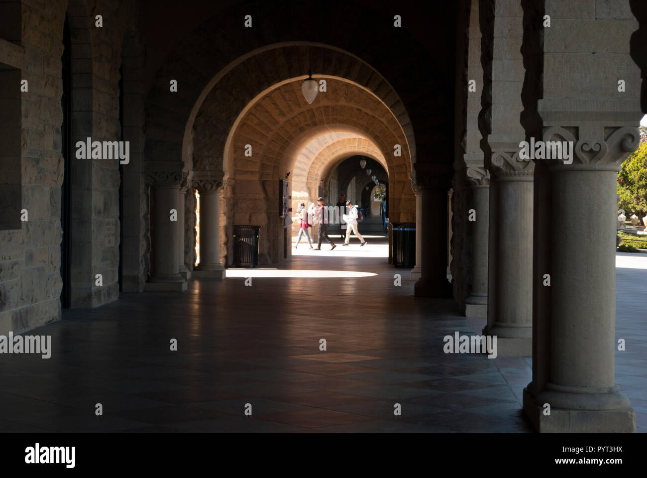 View through the arch on a large group of youth people walking. Group ...