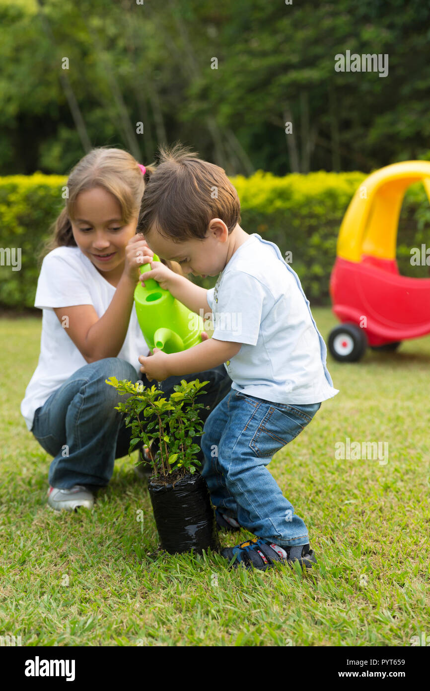 Happy Children Planting Garden In The Park Stock Photo - Alamy