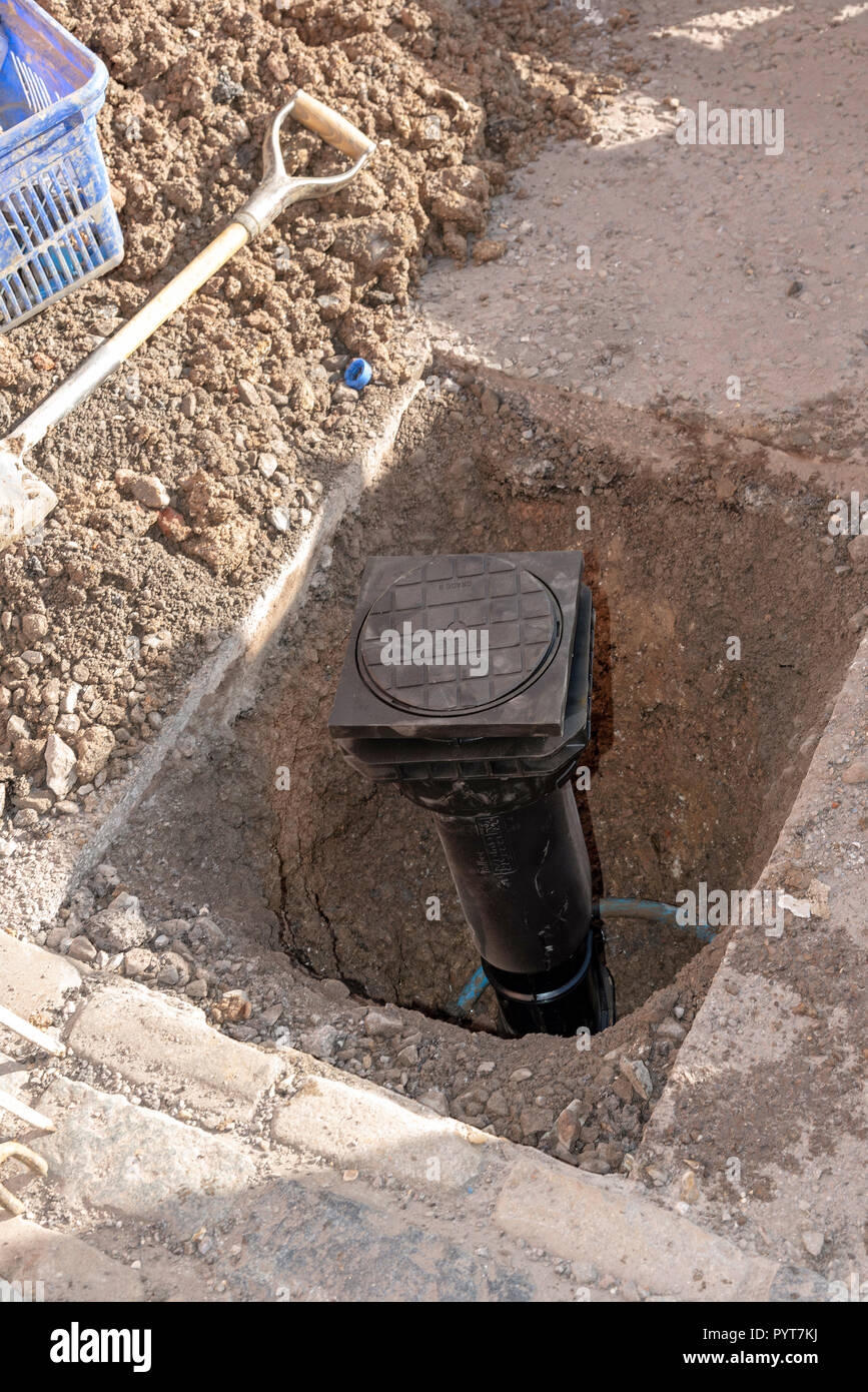 Installing a new water meter in the road. UK. The new black plastic ...