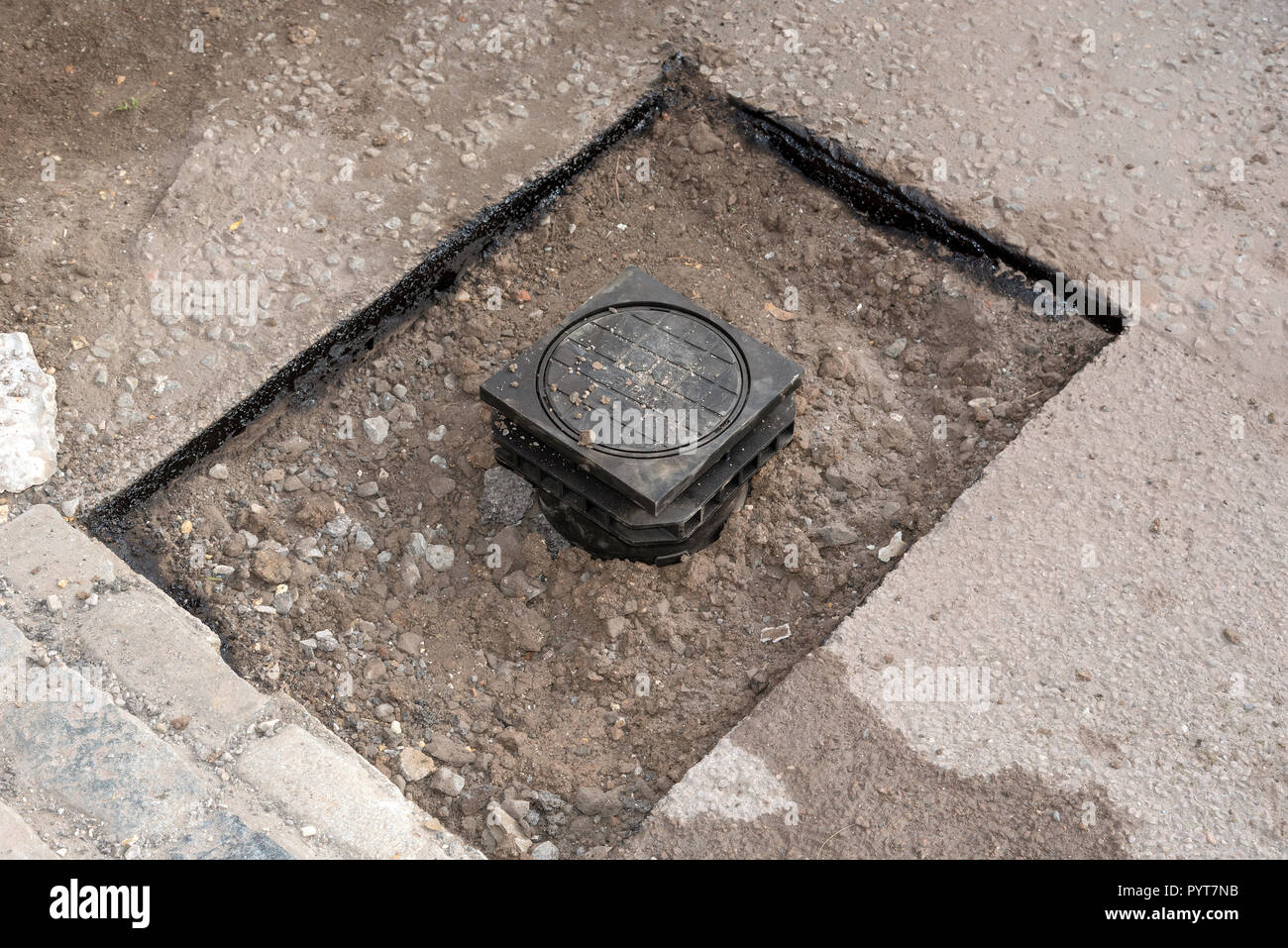 Installing a new water meter in the road. UK. The new meter in a filled ...