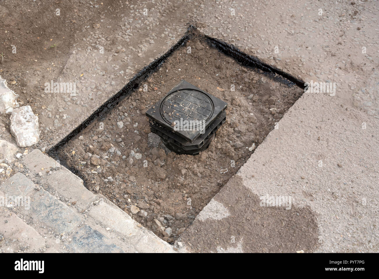 Installing a new water meter in the road. UK. The new meter in a filled ...