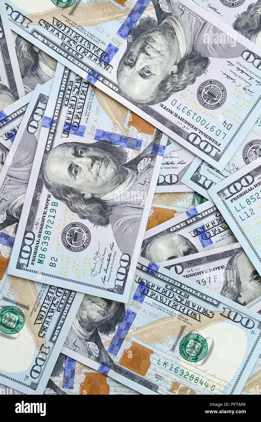 A large number of US dollar bills of a new design with a blue stripe in ...