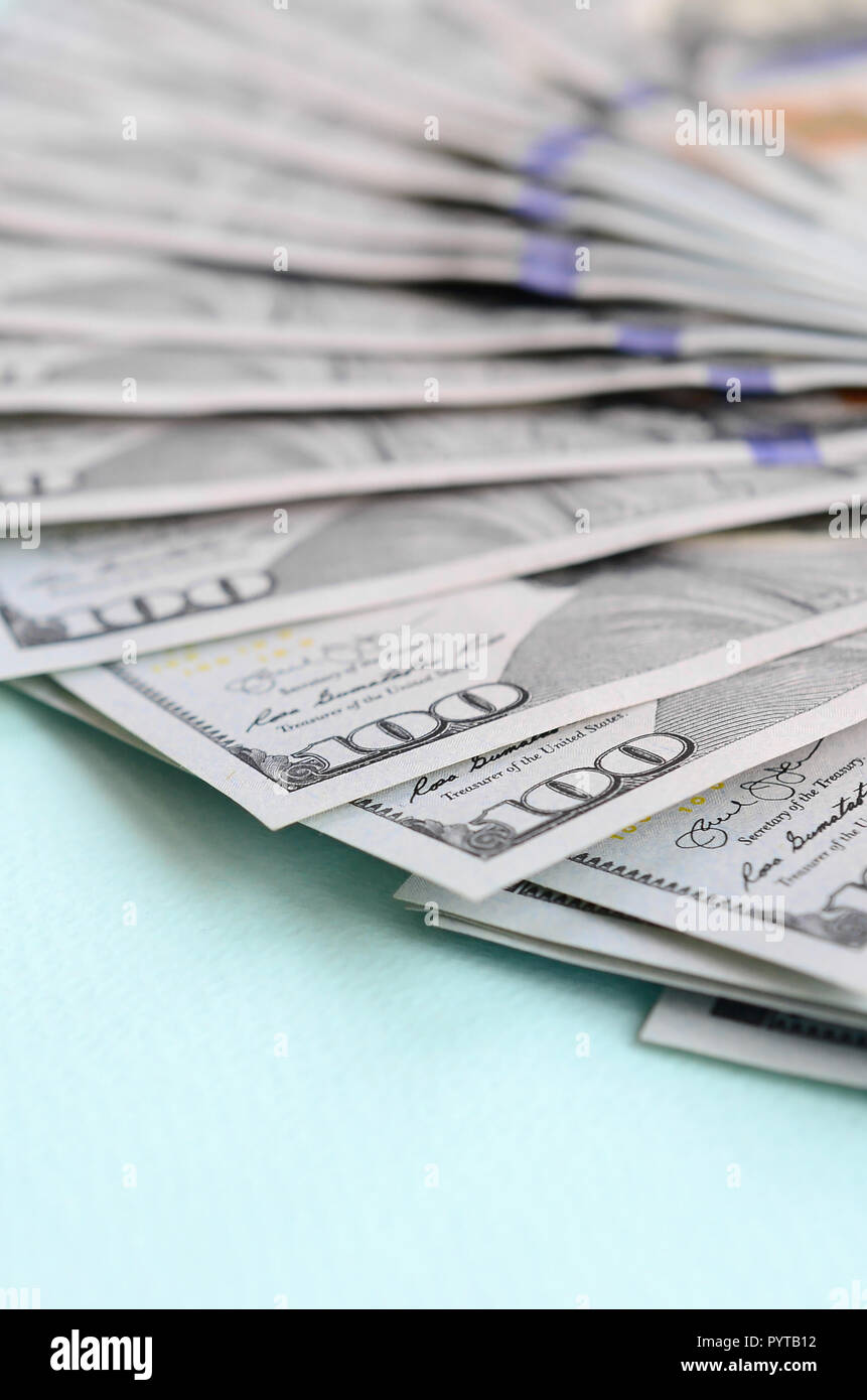 Fan of a US dollar bills of a new design lies on a light blue ...
