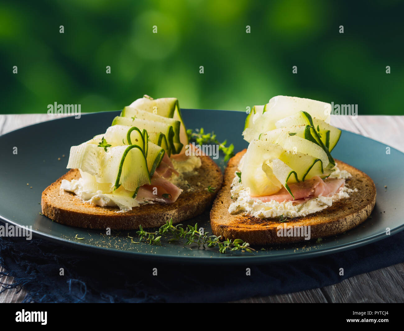 Rye bread toasts with fresh cheese, ham and cucumber slices. Bright ...