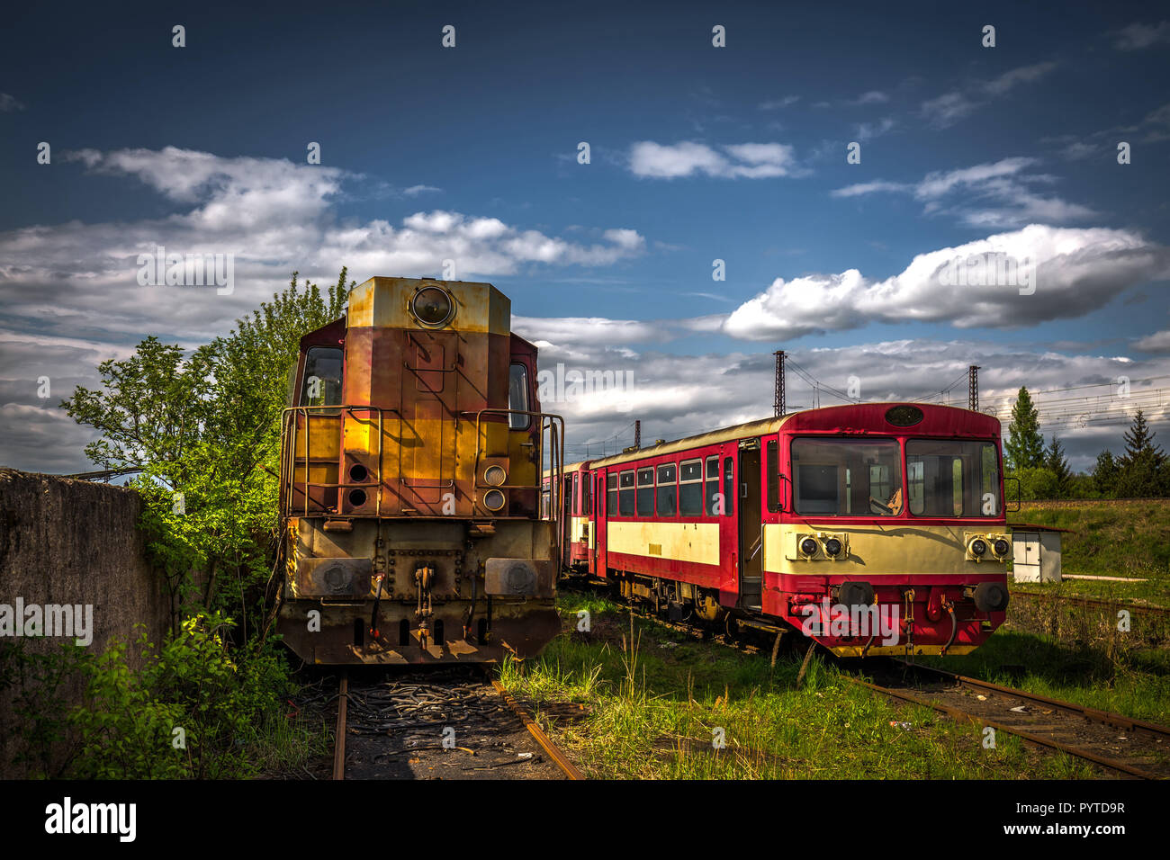 Old diesel locomotive in train cemetery in the summer with green grass ...