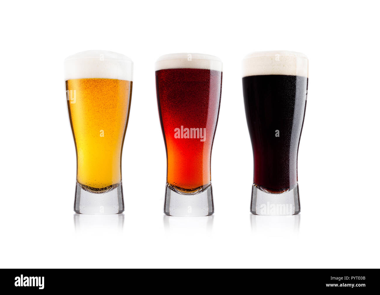 Cold glasses of lager stout and red beer with foam and dew on white ...