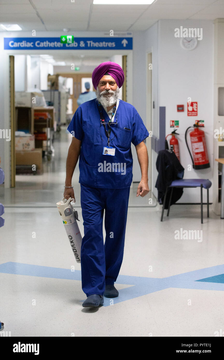 A Sikh Hospital technician carries an Oxygen tank along an NHS hospital ...
