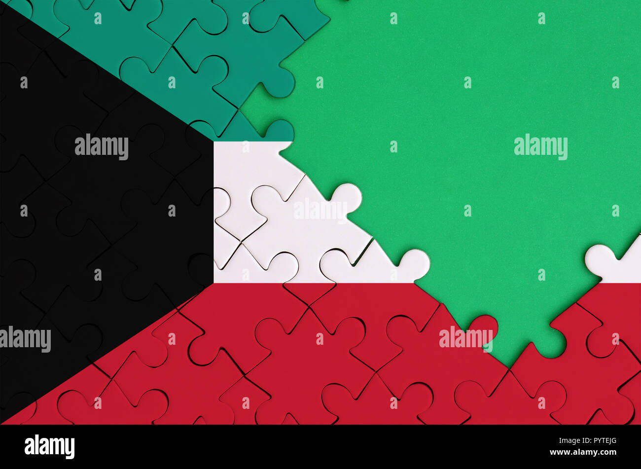 Kuwait flag is depicted on a completed jigsaw puzzle with free green ...