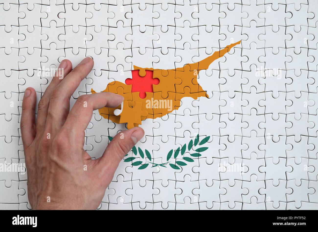 Cyprus flag is depicted on a puzzle, which the man's hand completes to ...