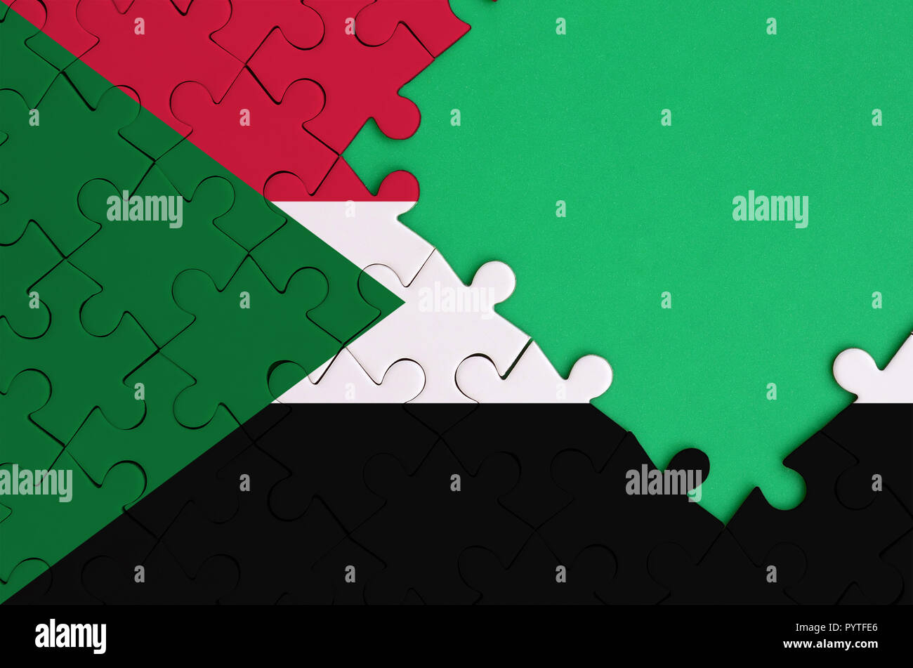 Sudan flag is depicted on a completed jigsaw puzzle with free green ...