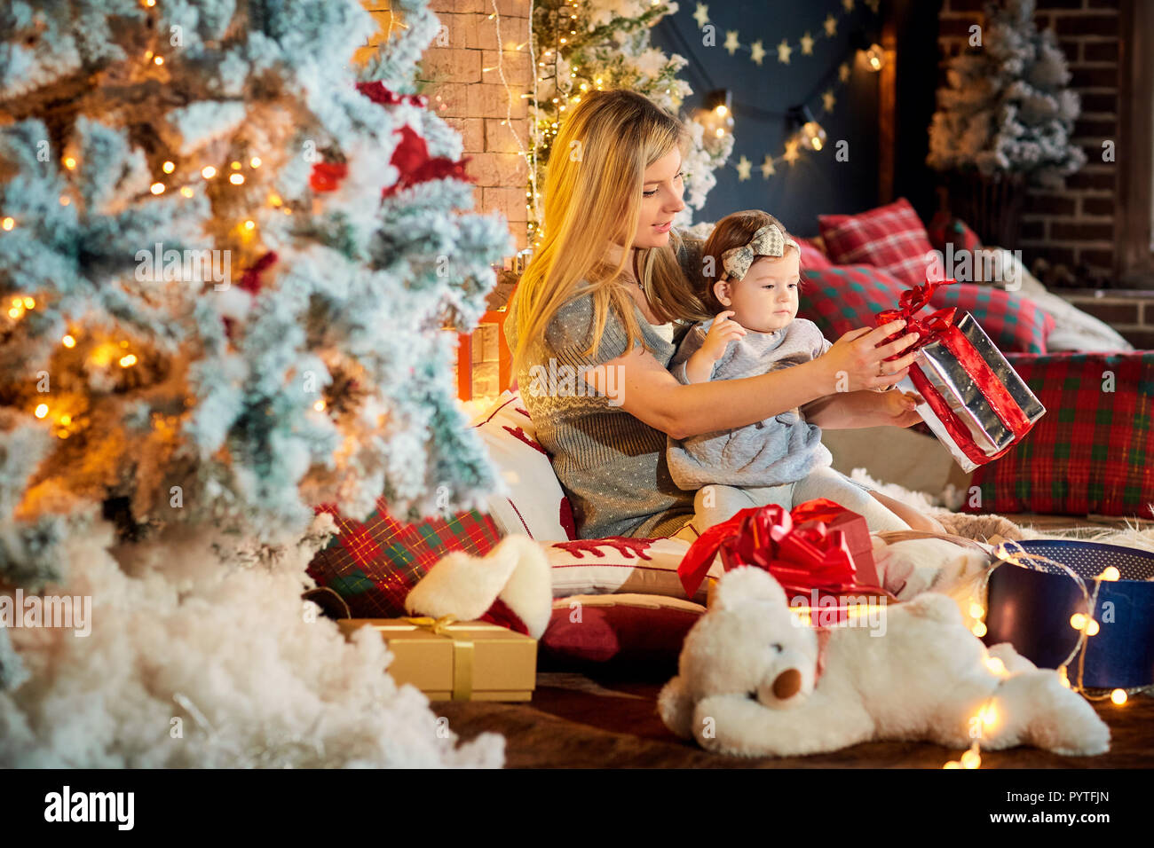 Mother with baby in a hat of Santa Claus in the Christmas room ...