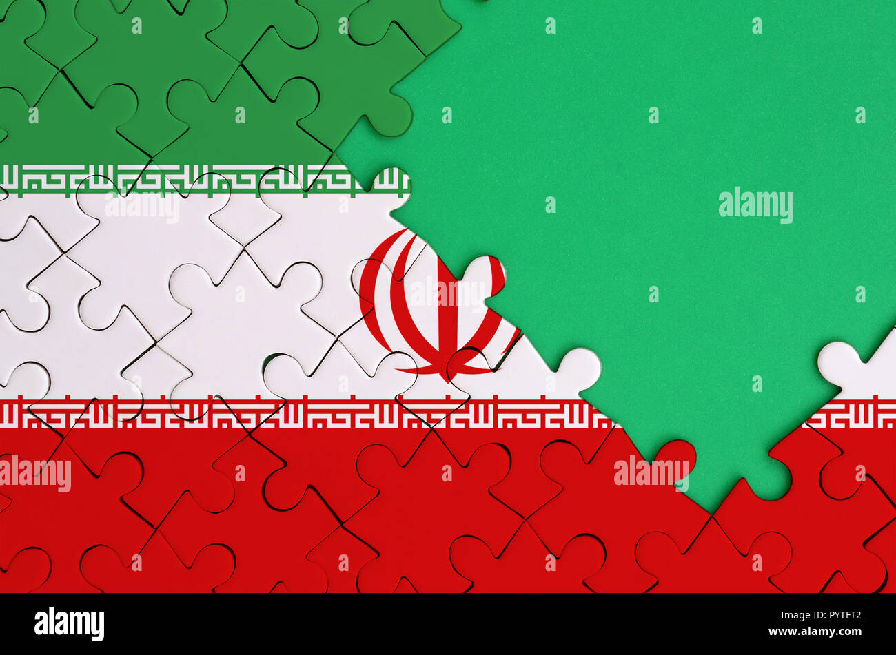 Iran flag is depicted on a completed jigsaw puzzle with free green copy ...
