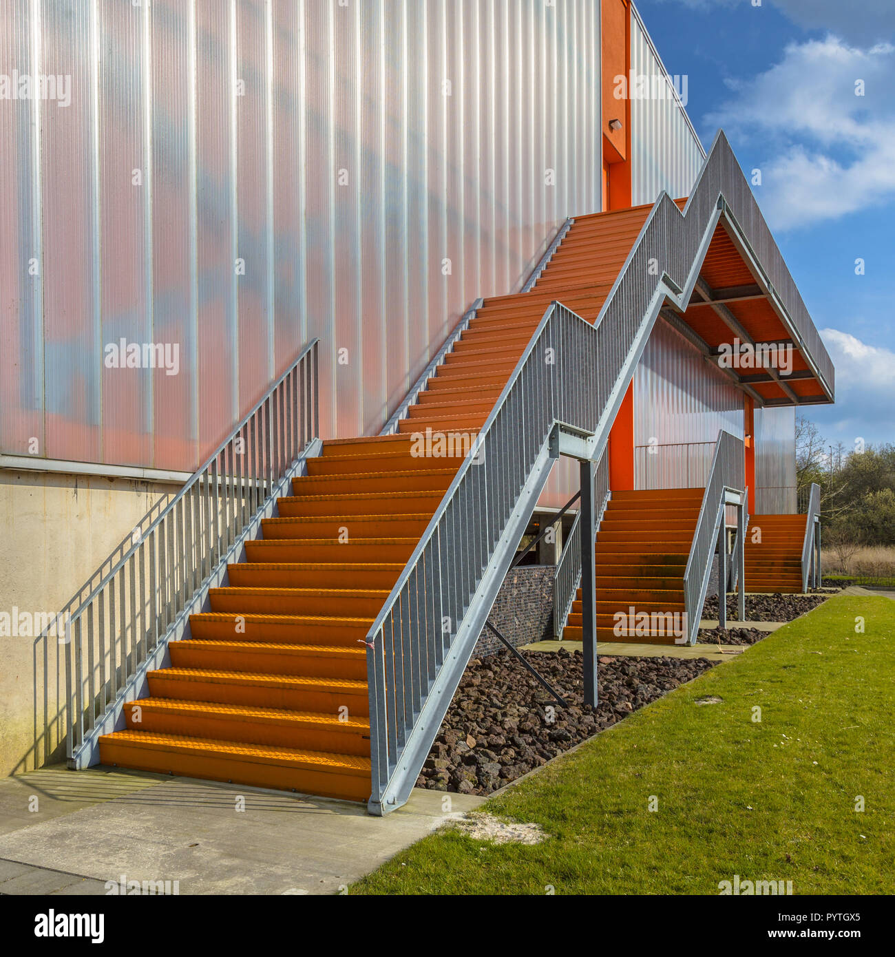 Modern emergency exit escape ladders on the exterior of an orange ...