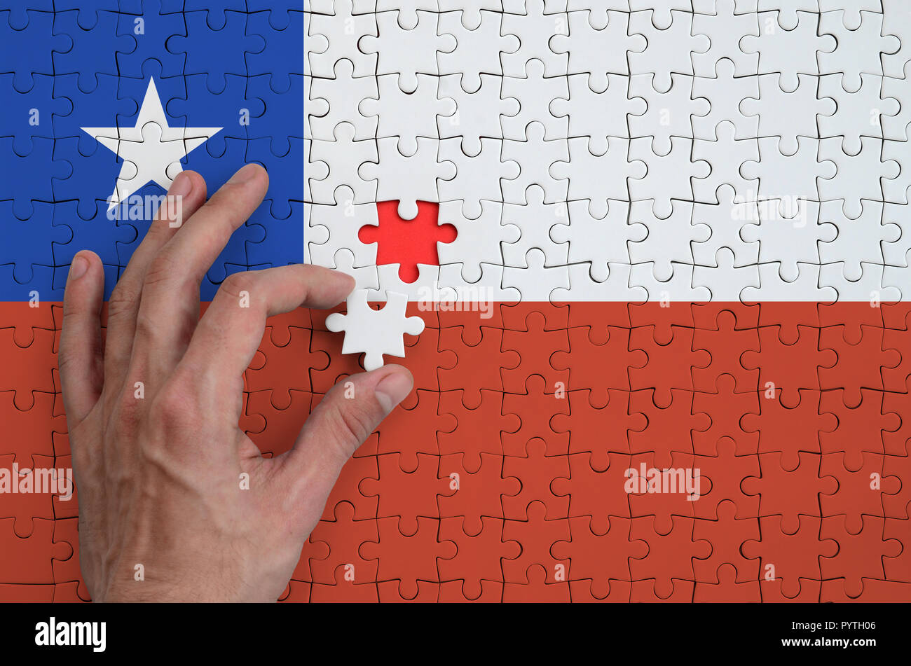 Chile flag is depicted on a puzzle, which the man's hand completes to ...