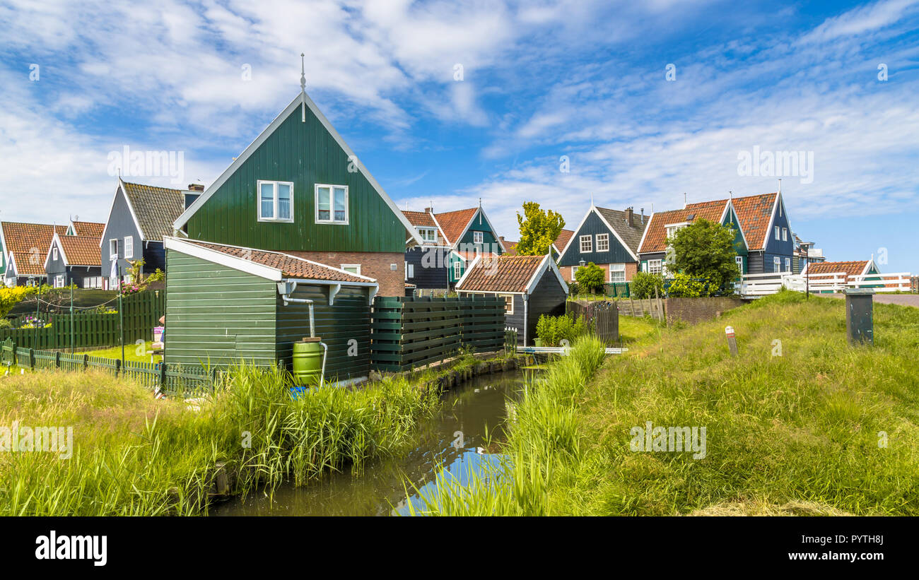 Traditional Dutch village scene with wooden houses and canal on the ...