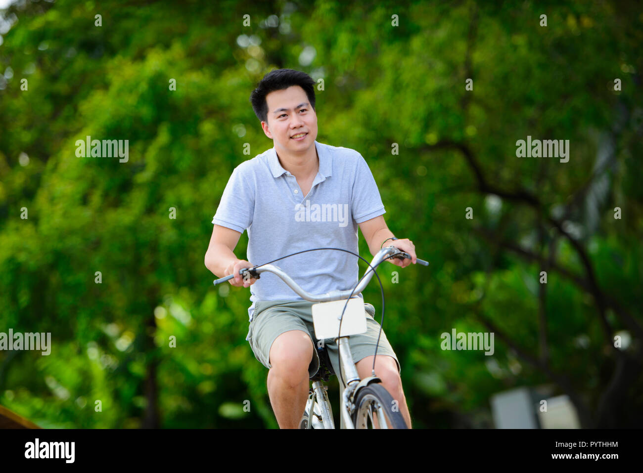 Young asian man riding a vintage bicycle in a park Stock Photo - Alamy