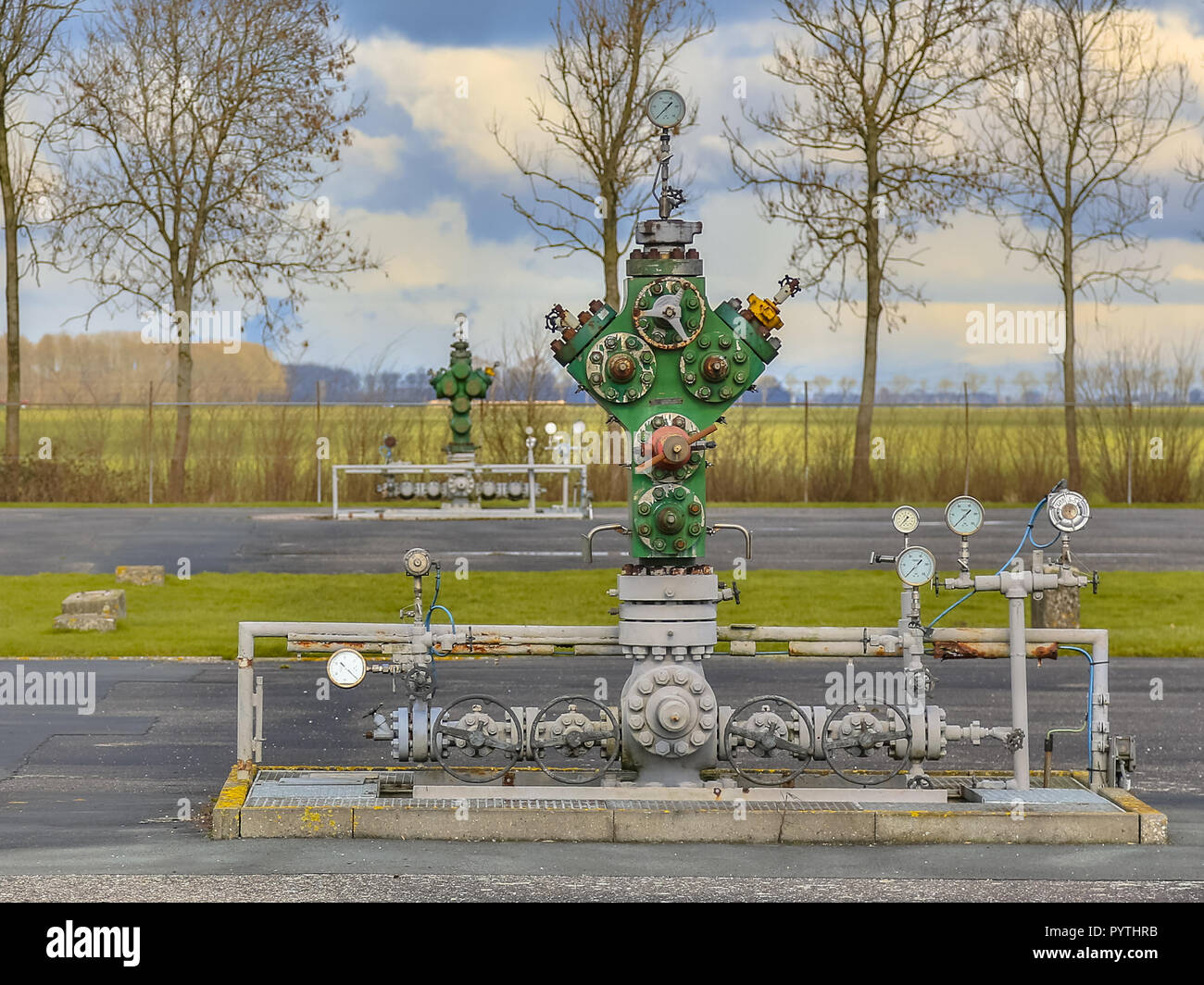 Old vintage wellhead in working natural gas field processing site in ...