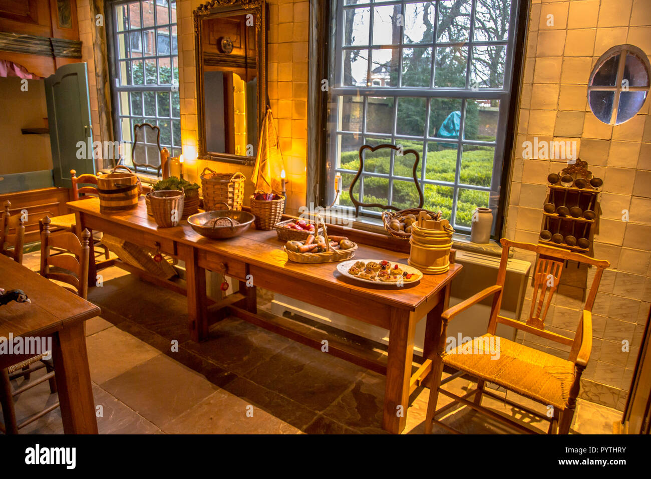 Historic kitchen table in old dutch building with pastry and vegetables ...