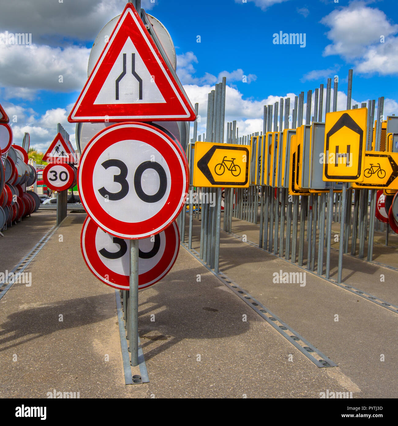 Bottleneck road narrowing sign and speed limit sign among other rows of ...
