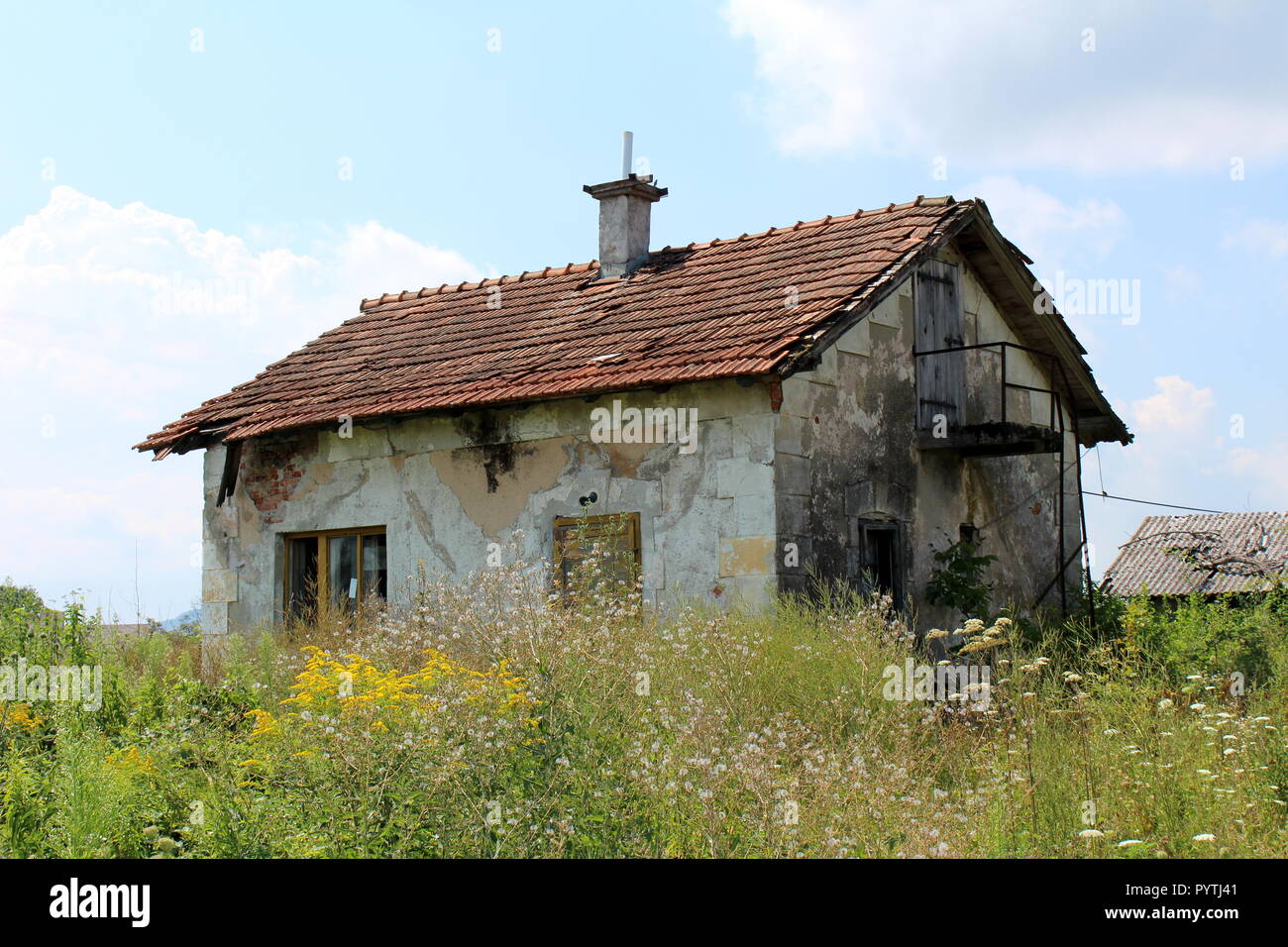 Burned small abandoned family house with completely dilapidated facade, destroyed doors and ...