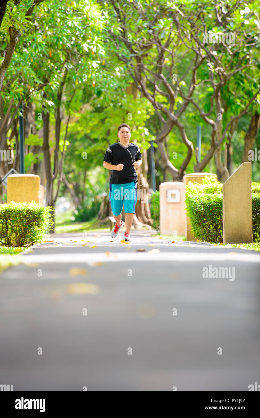Asian man jogging green park hi-res stock photography and images - Alamy