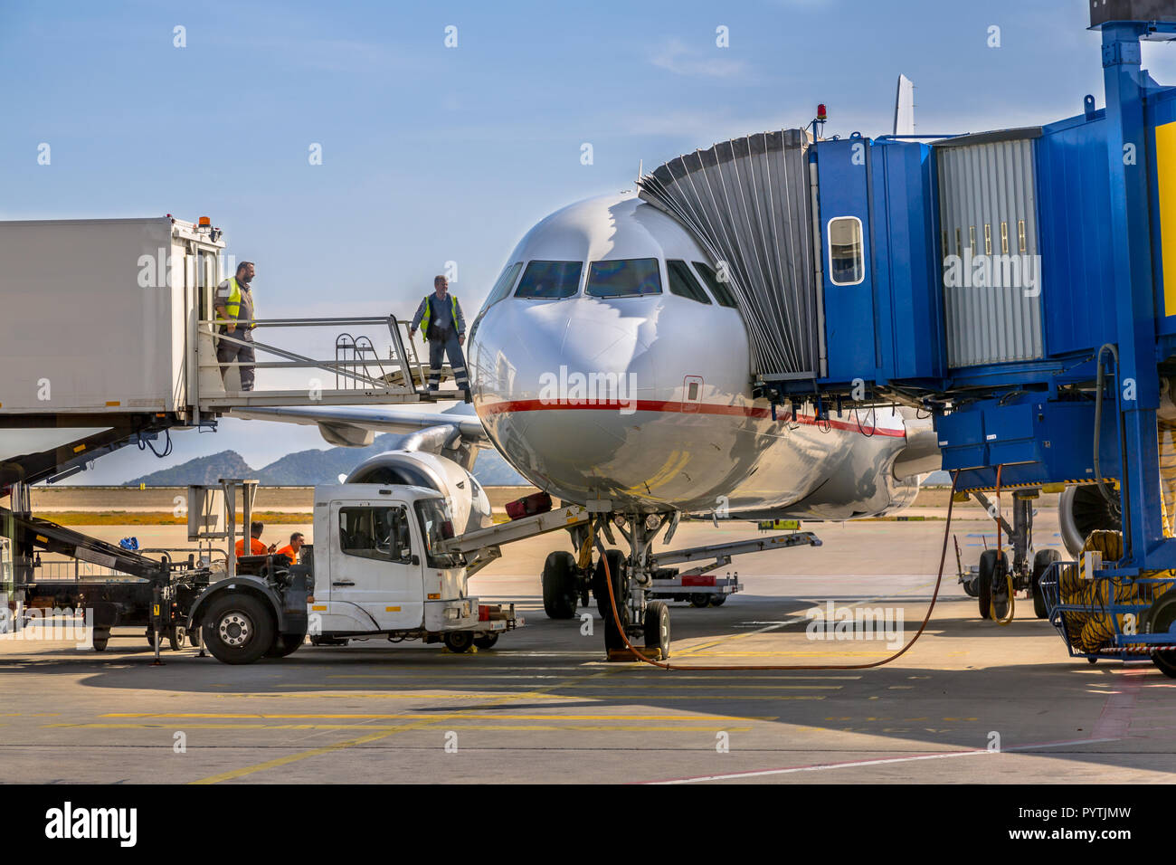 Frontal view of passenger jet airplane docked at gate terminal ...