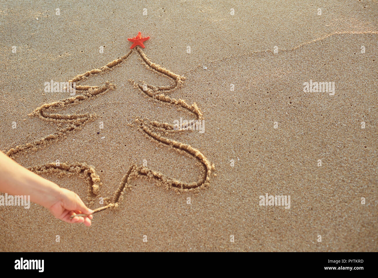 The concept of Christmas. Painted Christmas tree in the sand on the ...