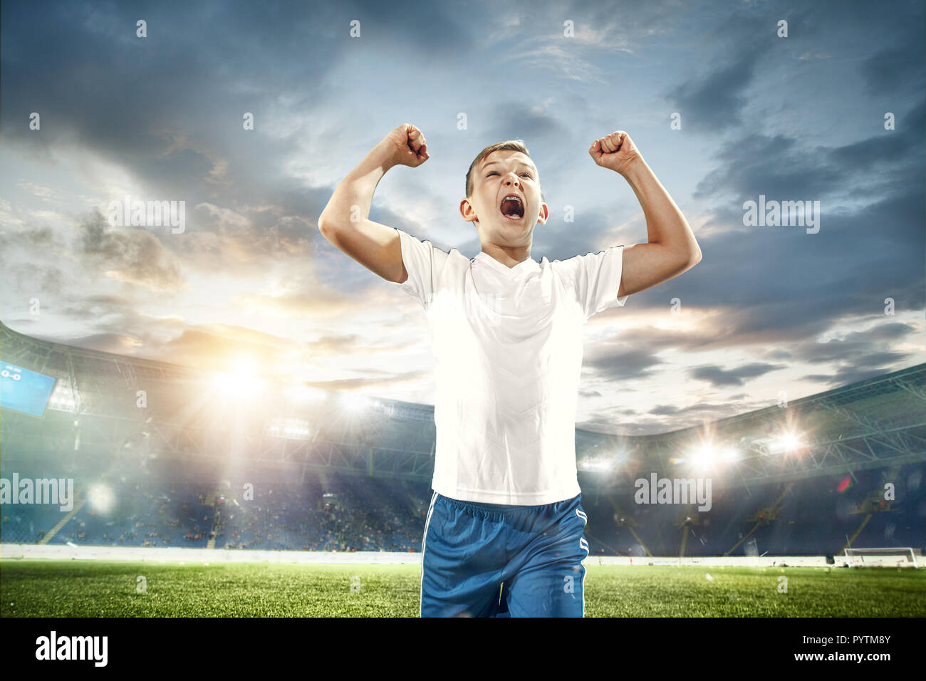 Young boy as winner at stadium. football youth soccer player in motion ...