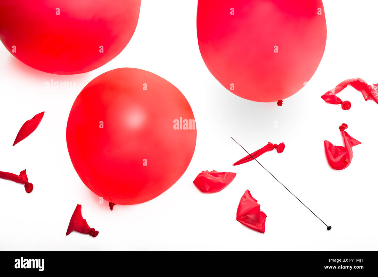 Old fashioned hat pin and a collection of popped and inflated red ...